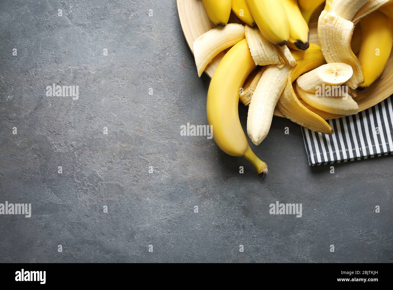 Ripe bananas on grey background Stock Photo - Alamy