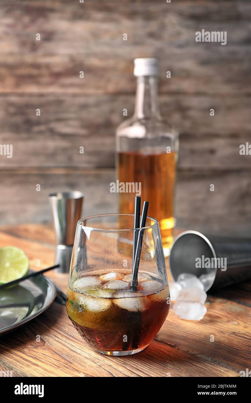 Glass of Cuba Libre cocktail on wooden table Stock Photo - Alamy