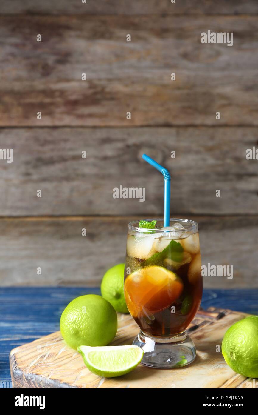 Glass of Cuba Libre cocktail on wooden table Stock Photo - Alamy