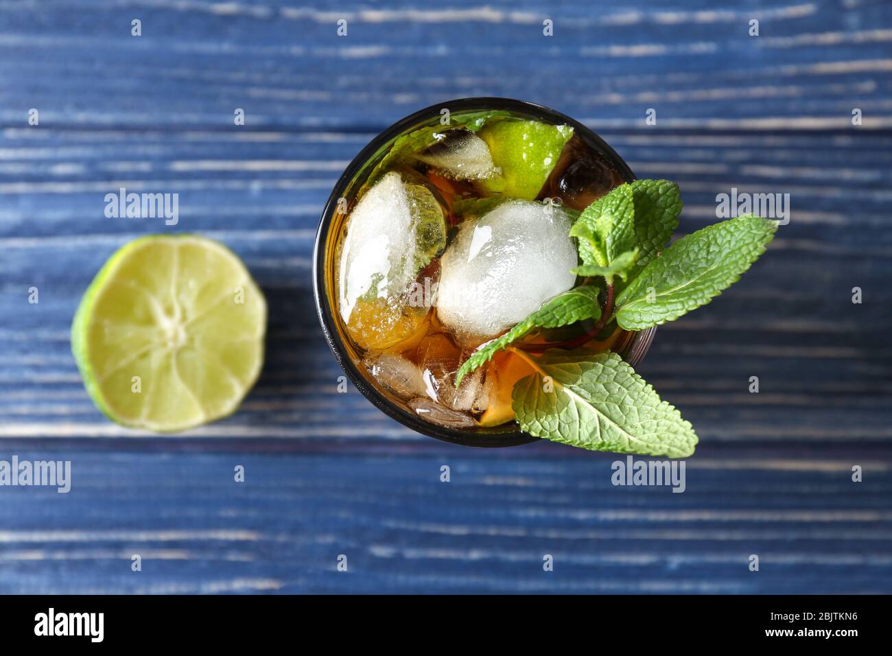 Glass of Cuba Libre cocktail on wooden table Stock Photo - Alamy