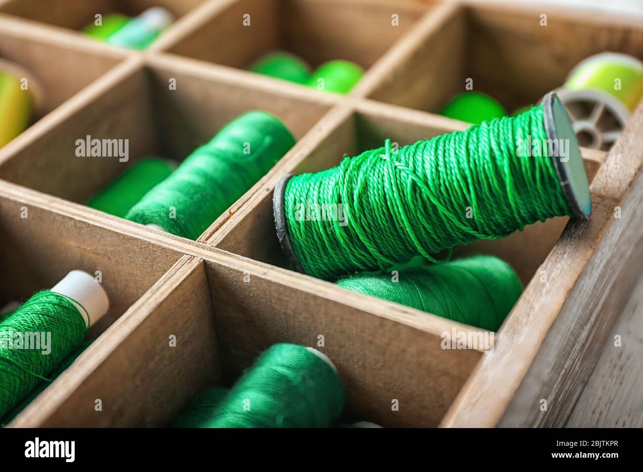 Set of green sewing threads in wooden compartment box Stock Photo - Alamy