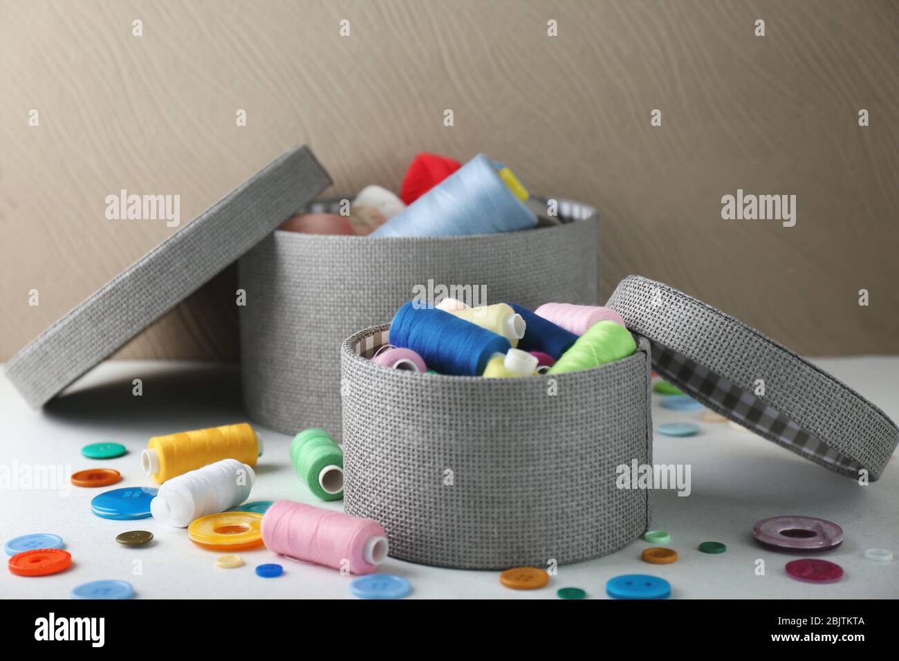 Boxes with color sewing threads and buttons on table Stock Photo - Alamy