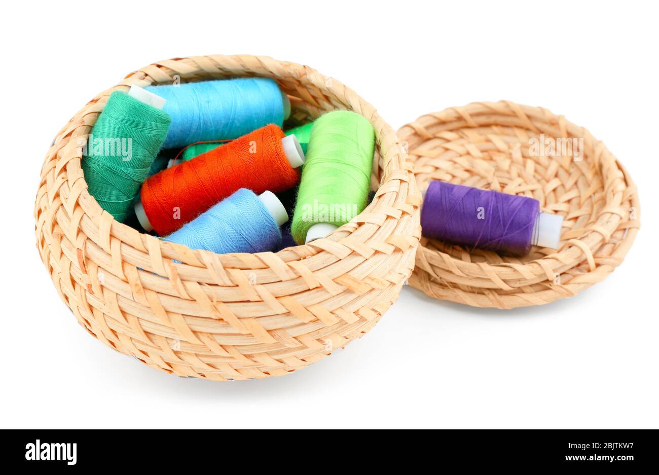Wicker box with color sewing threads on white background Stock Photo ...
