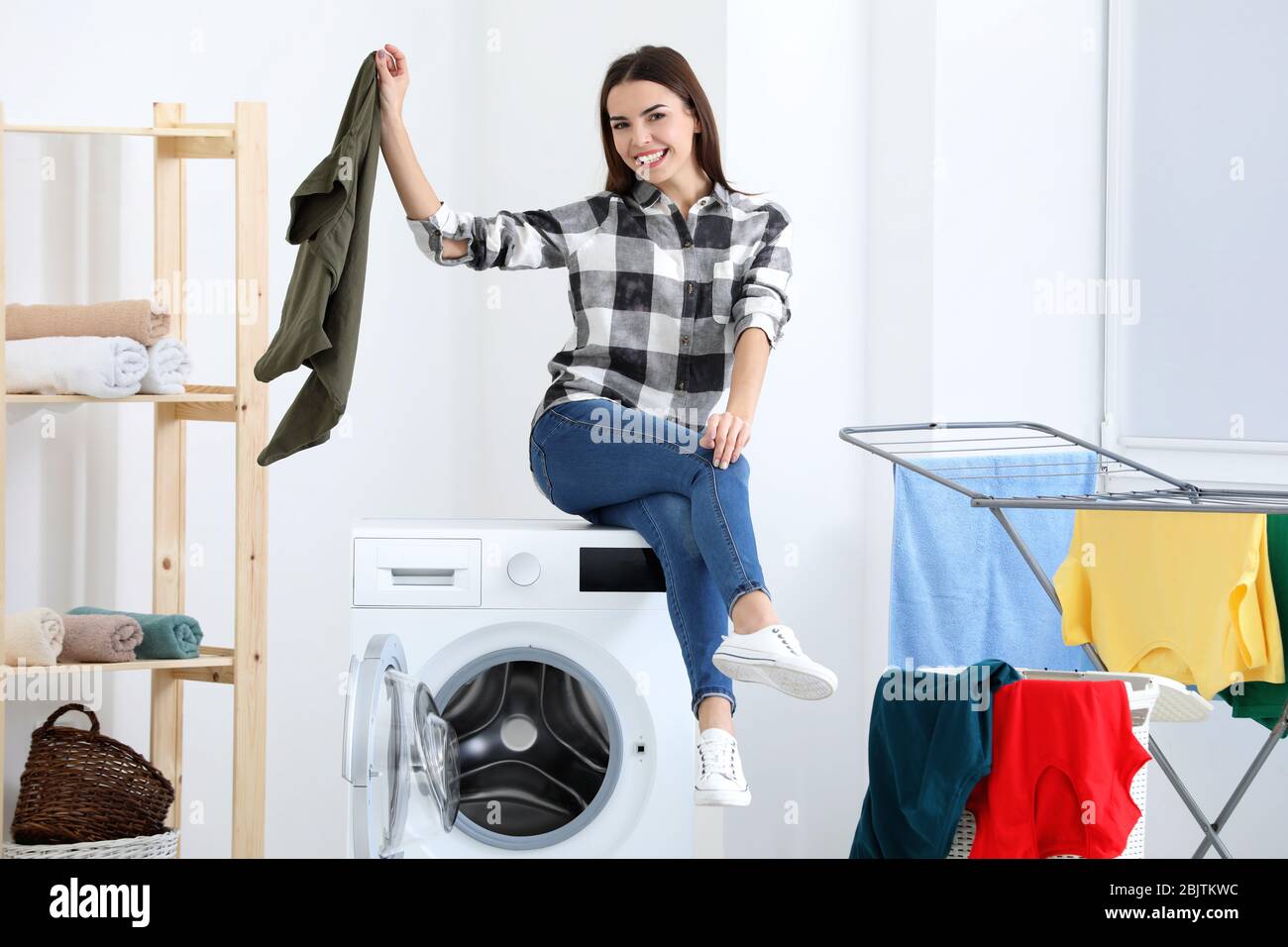 Young woman doing laundry at home Stock Photo - Alamy