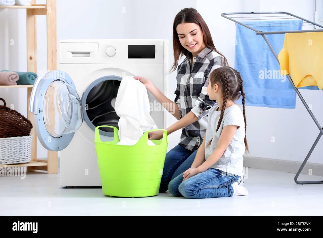 Daughter and mother doing laundry together at home Stock Photo - Alamy