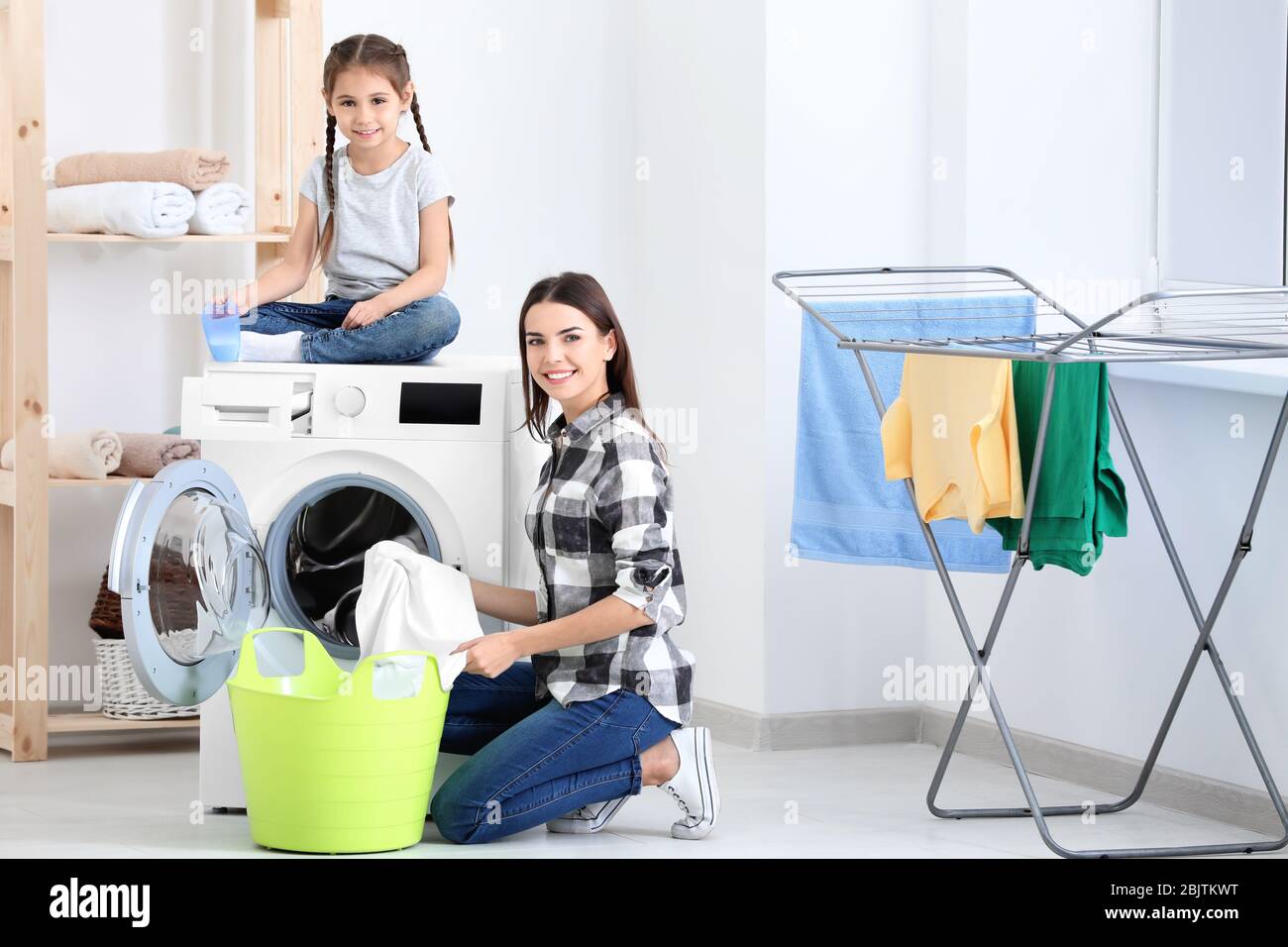 Daughter and mother doing laundry together at home Stock Photo - Alamy