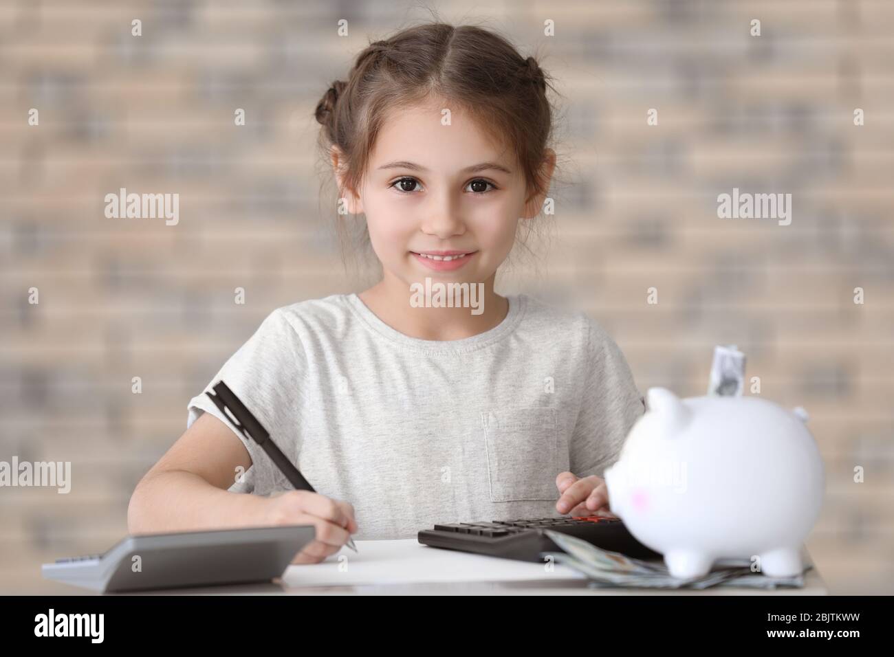 Cute little girl counting money at table Stock Photo - Alamy