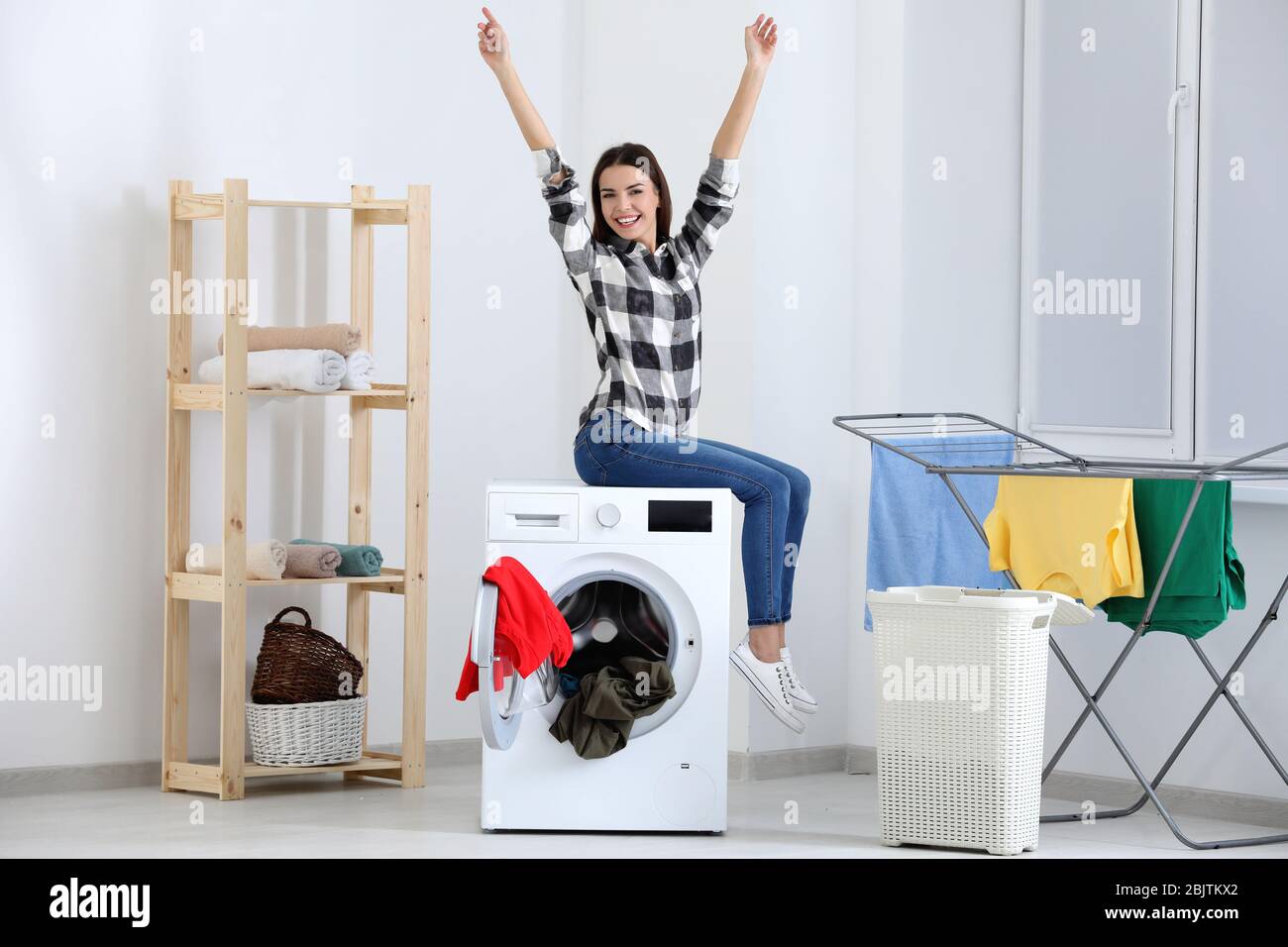 Young woman doing laundry at home Stock Photo - Alamy