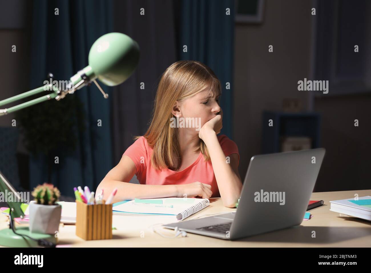 Teenage girl doing homework at table in evening Stock Photo - Alamy