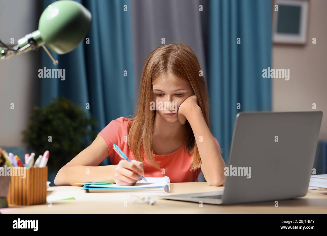 Teenage girl doing homework at table Stock Photo - Alamy