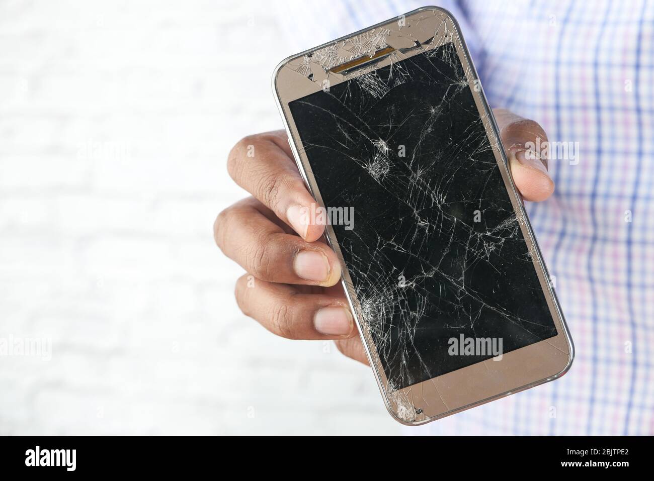man holding smartphone with a broken screen Stock Photo - Alamy