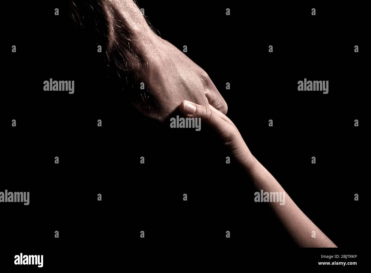 Adult and child holding hands on black background adult hand supporting ...