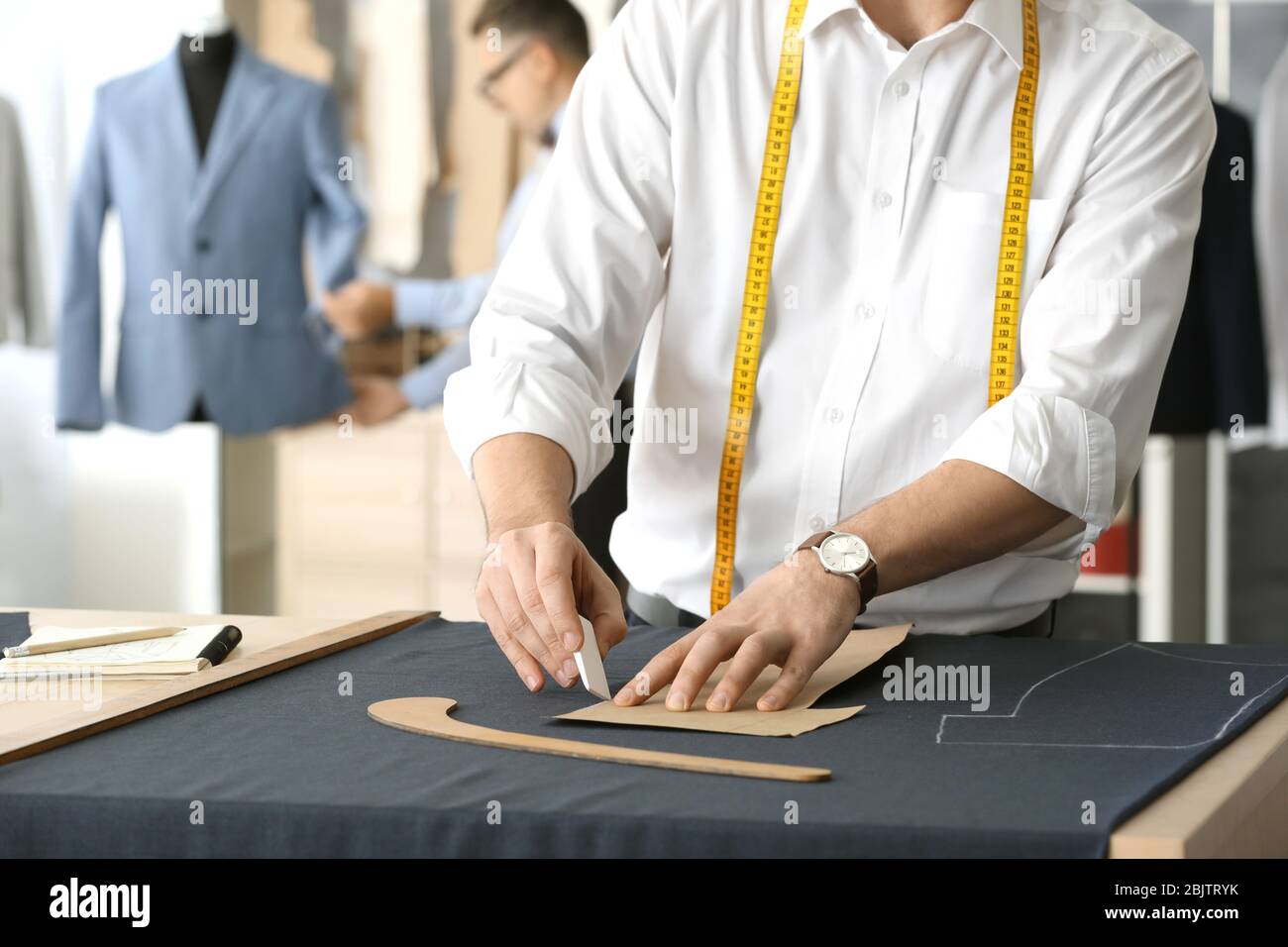 Tailor marking fabric with chalk in atelier Stock Photo - Alamy