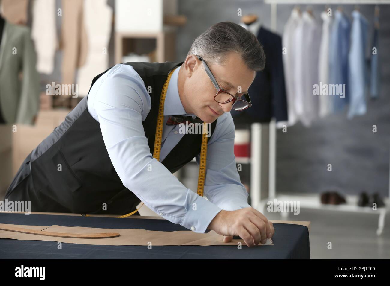 Tailor marking fabric with chalk in atelier Stock Photo - Alamy