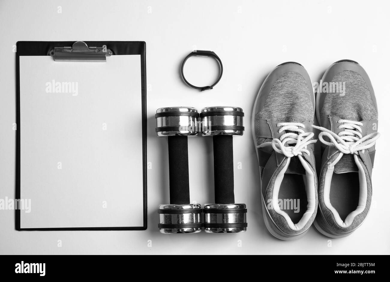 Clipboard with blank paper for exercise plan and gym stuff on white ...