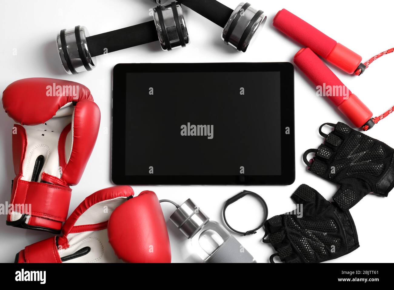 Gym stuff and tablet with blank space for exercise plan on white ...