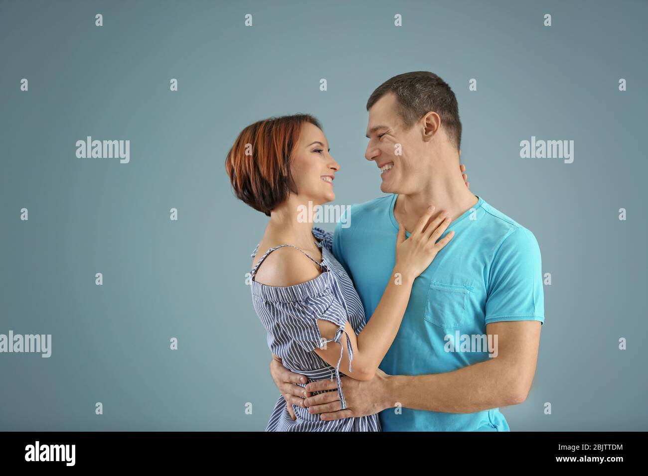 Portrait of cute loving couple on color background Stock Photo - Alamy