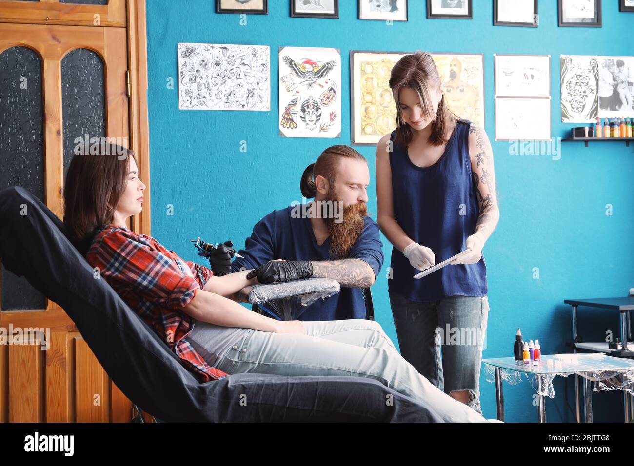 Professional tattoo artist teaching trainee in salon. Apprenticeship ...