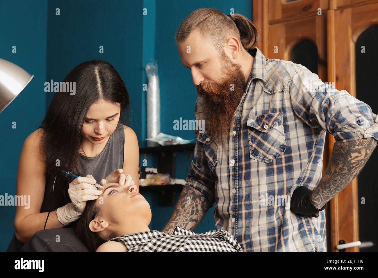 Professional tattoo artist teaching trainee in salon. Apprenticeship ...