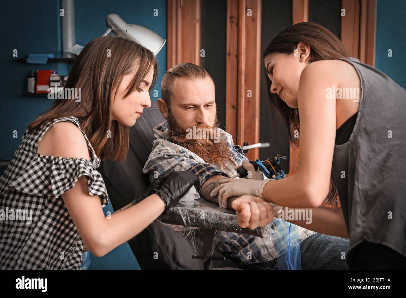 Professional tattoo artist teaching trainee in salon. Apprenticeship ...