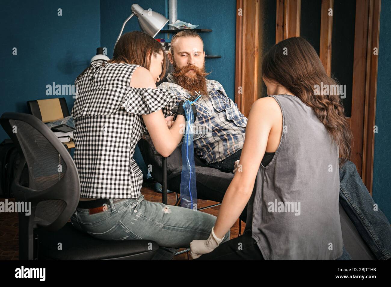 Professional tattoo artist teaching trainee in salon. Apprenticeship ...
