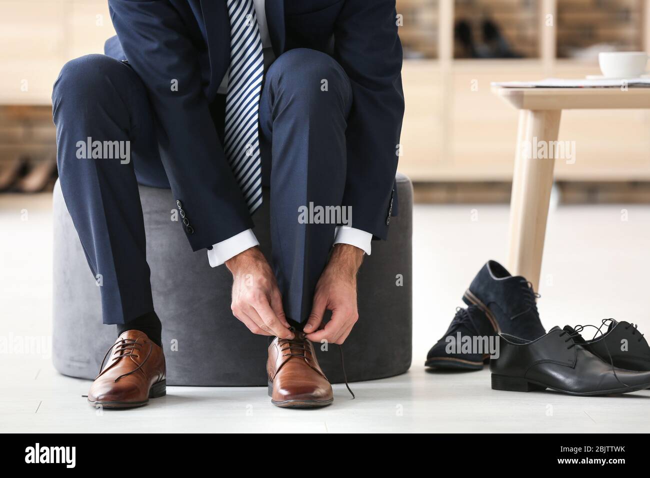 Young man trying on shoes in shop Stock Photo - Alamy