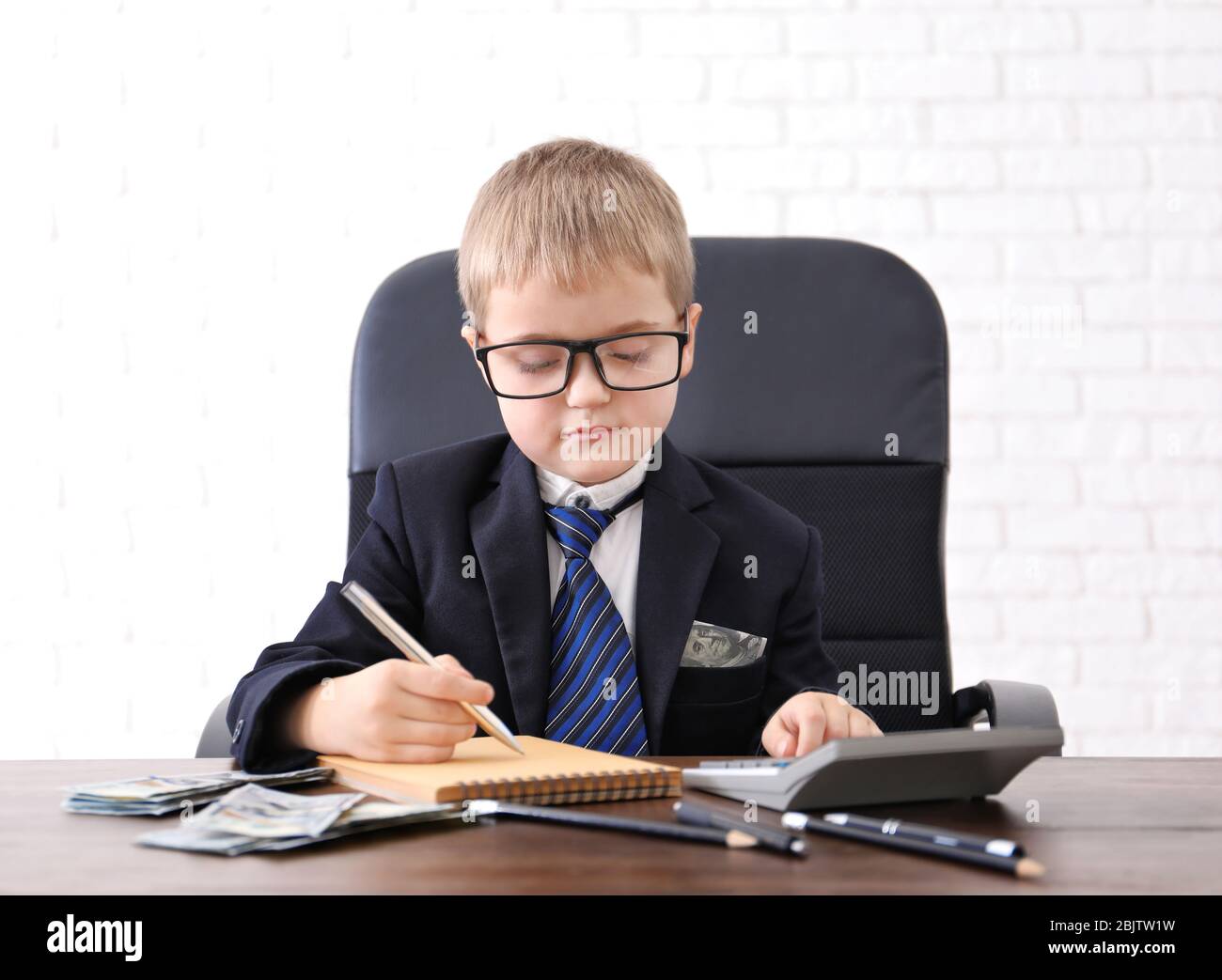 Cute little boy counting money at table indoors Stock Photo - Alamy