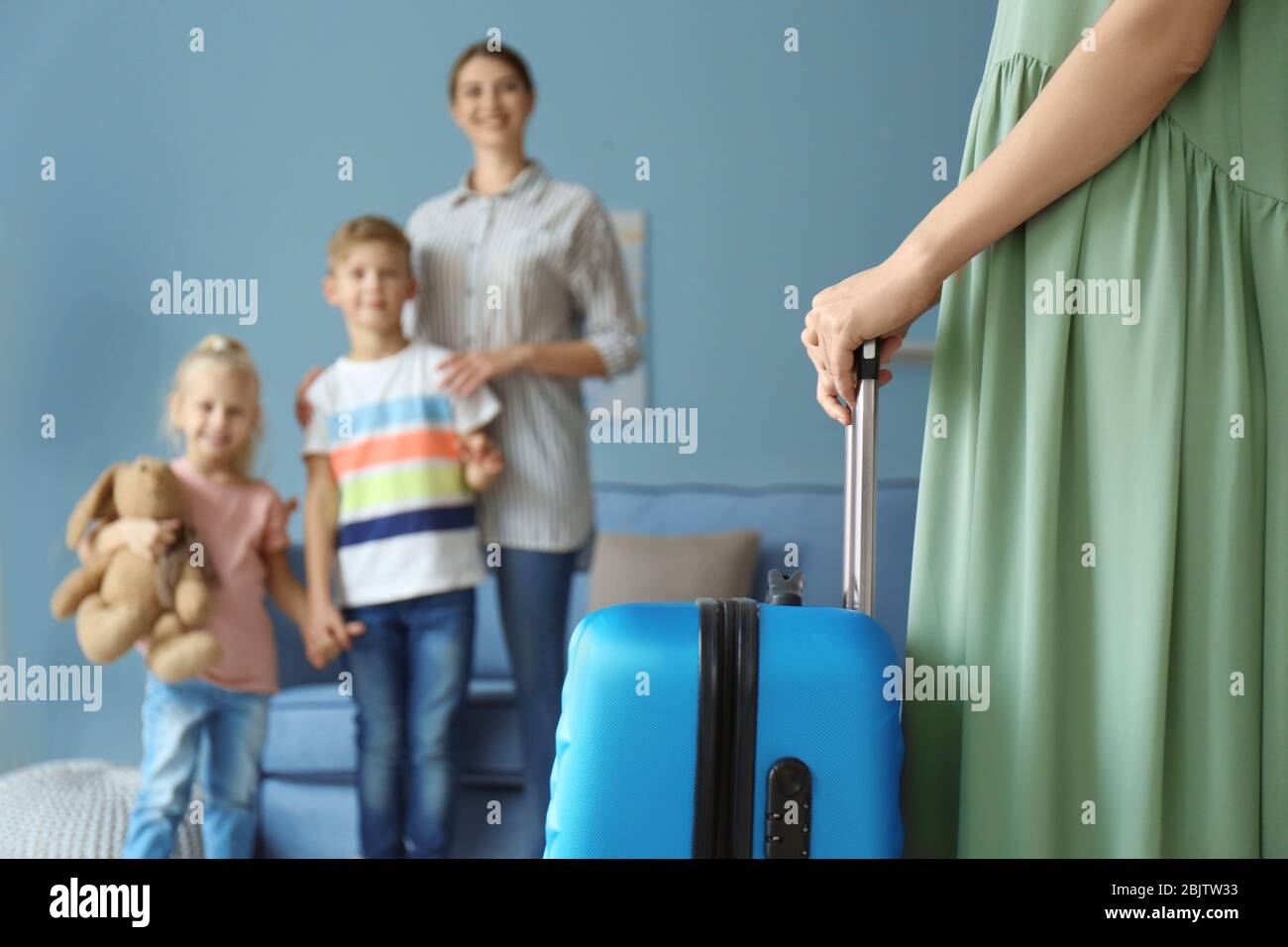Mother leaving her children with nanny at home Stock Photo - Alamy