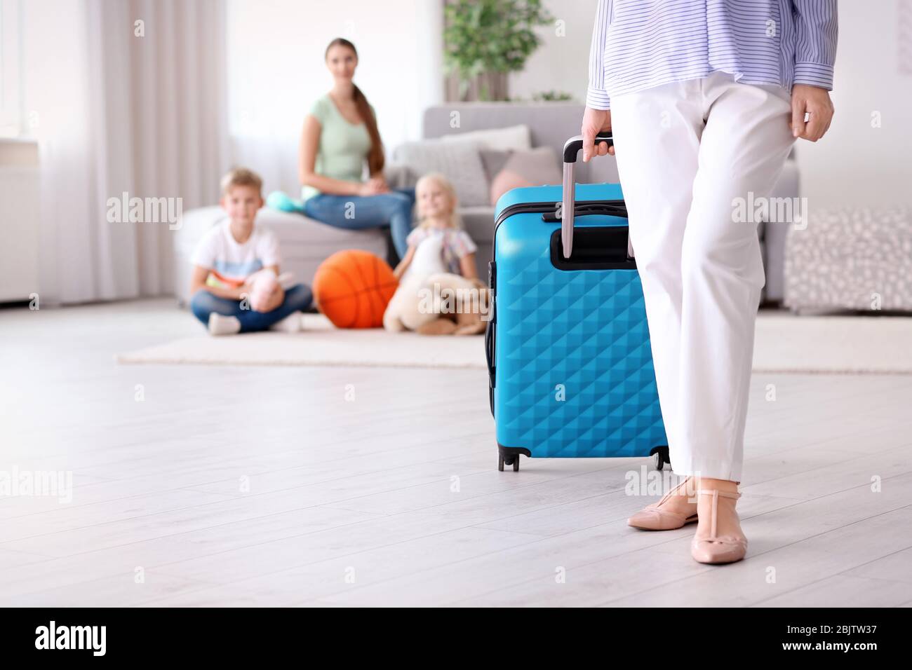 Mother leaving her children with nanny at home Stock Photo - Alamy