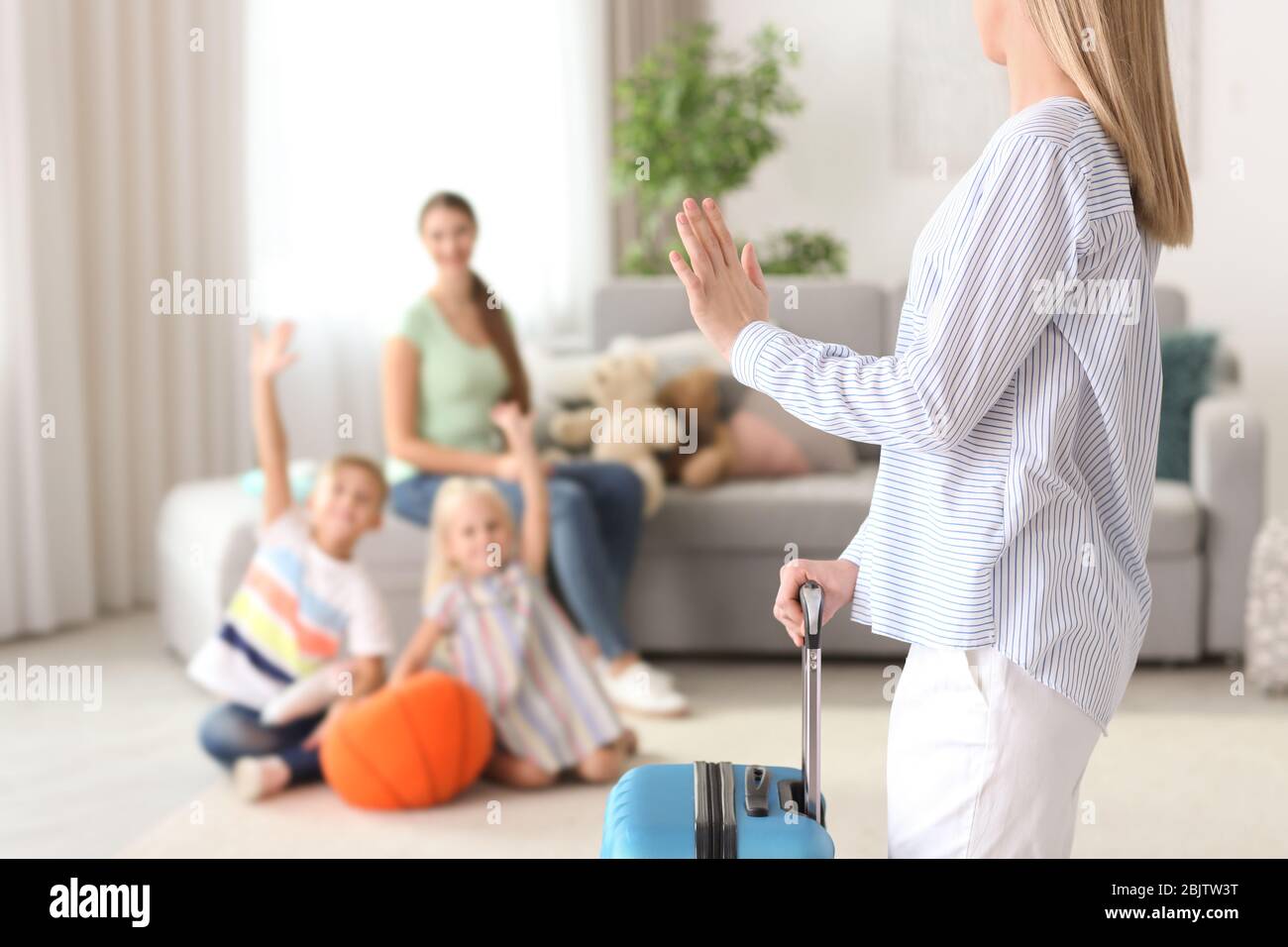 Mother leaving her children with nanny at home Stock Photo - Alamy