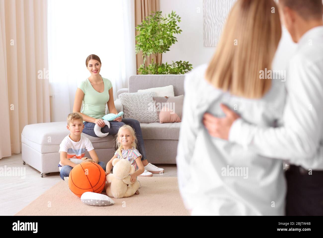 Parents leaving their children with nanny at home Stock Photo - Alamy