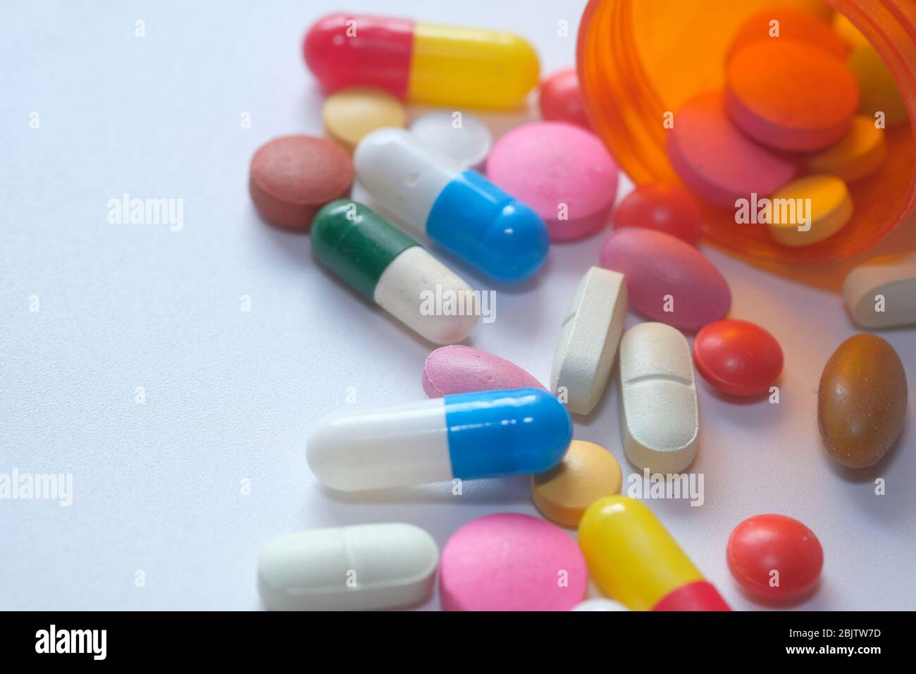bottle of colorful pills white background Stock Photo - Alamy