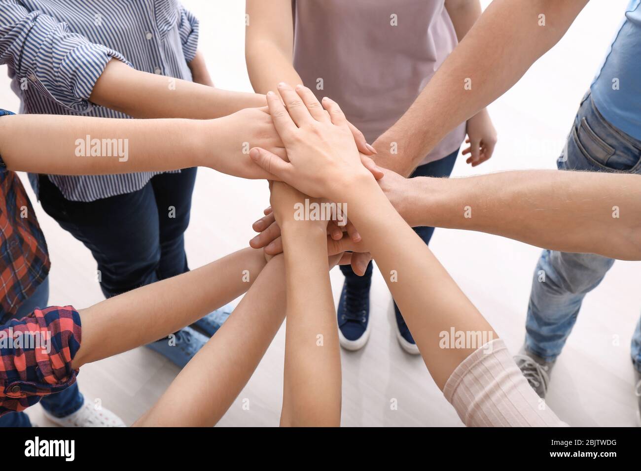 Young people putting hands together as symbol of unity Stock Photo - Alamy