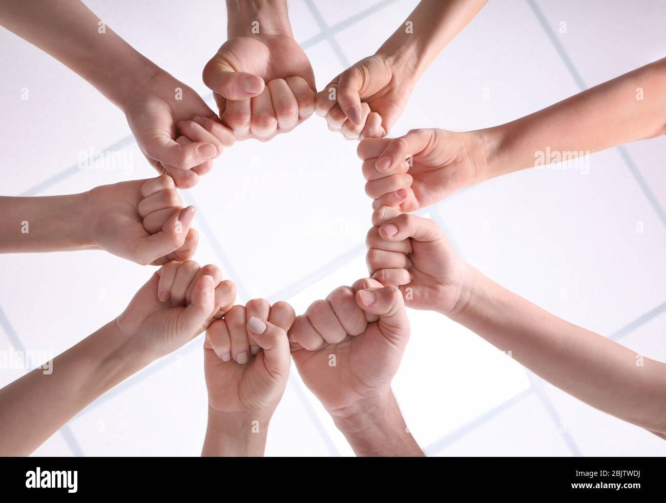Young people putting their fists together in circle as symbol of unity ...
