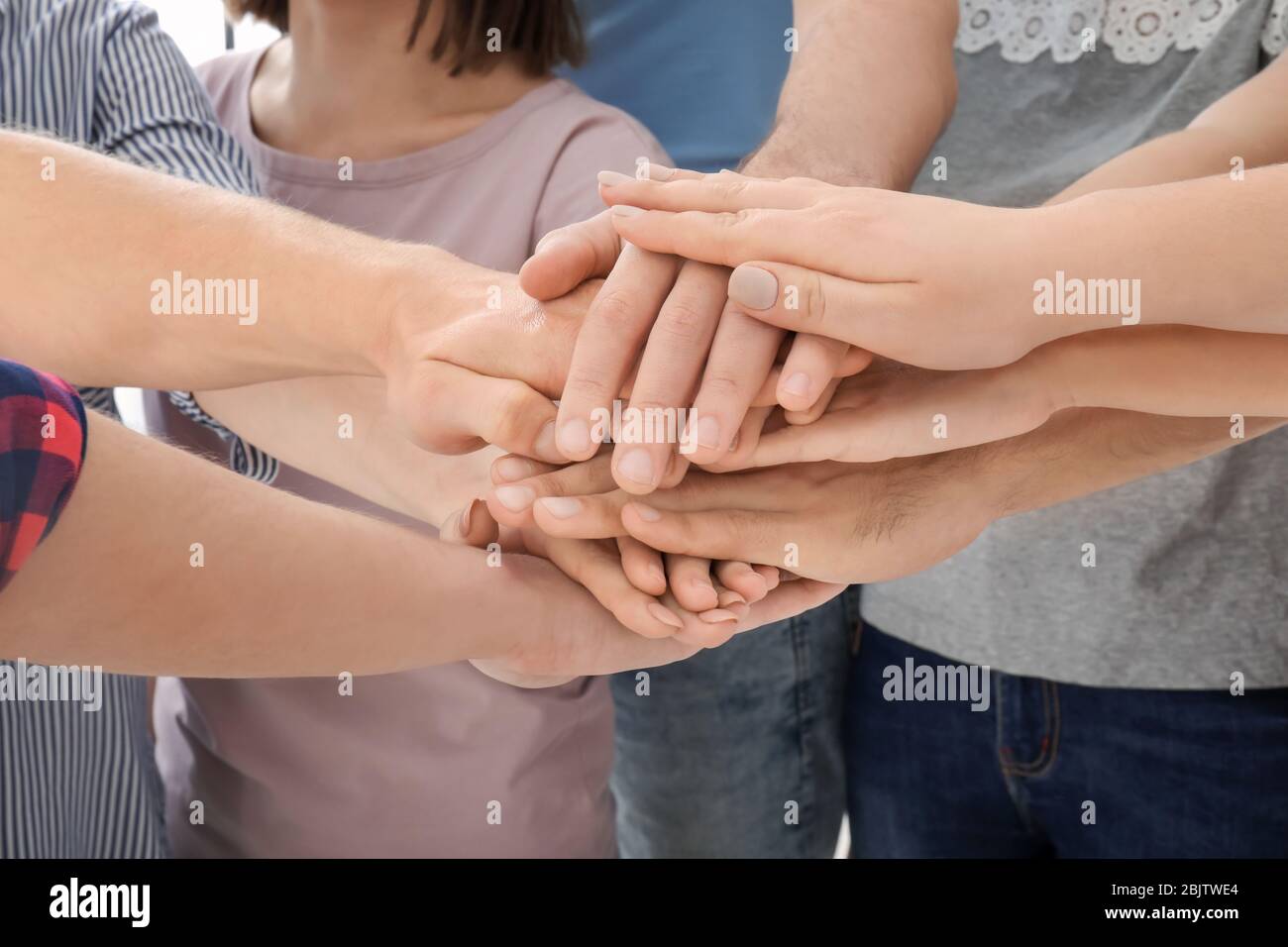 Young people putting hands together as symbol of unity, closeup Stock ...