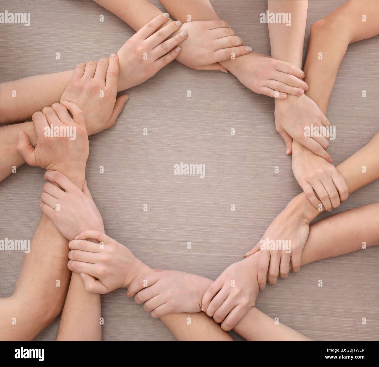 Group of people making circle with their hands on wooden background ...