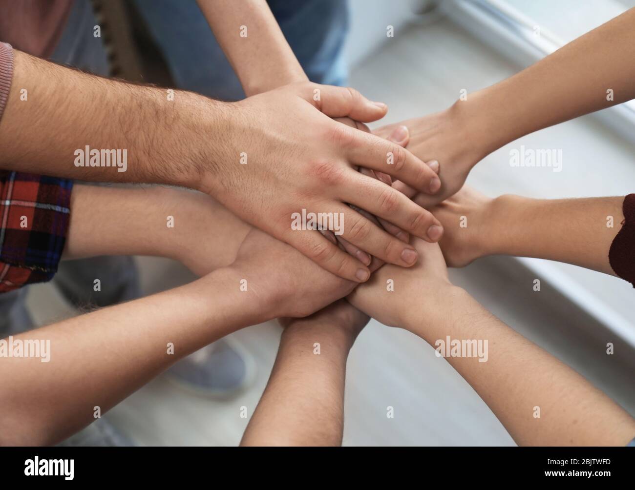 Young people putting hands together as symbol of unity Stock Photo - Alamy