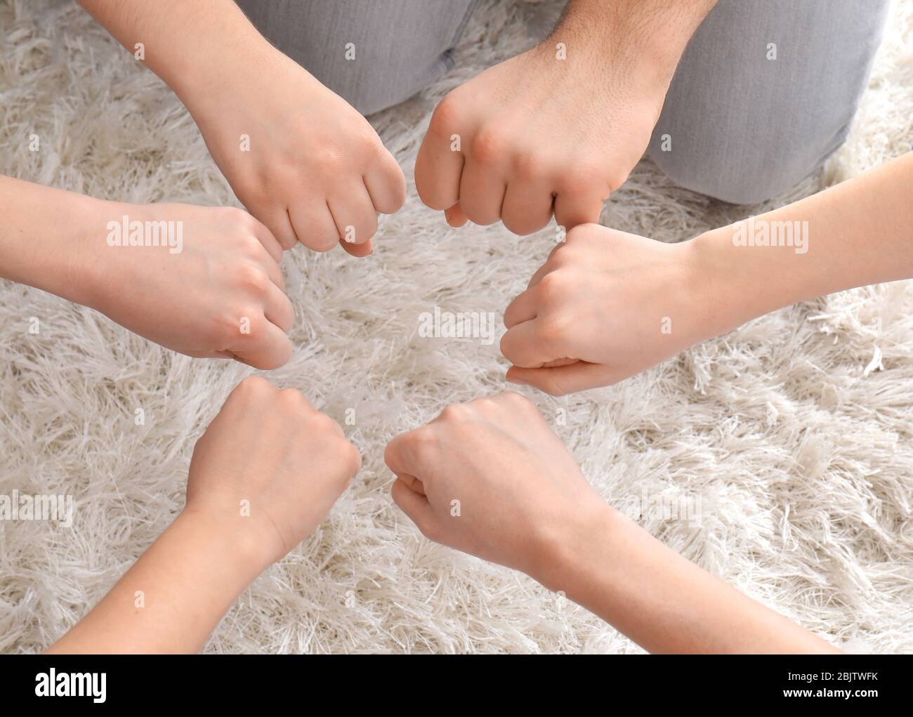 Young people putting their fists together in circle as symbol of unity ...