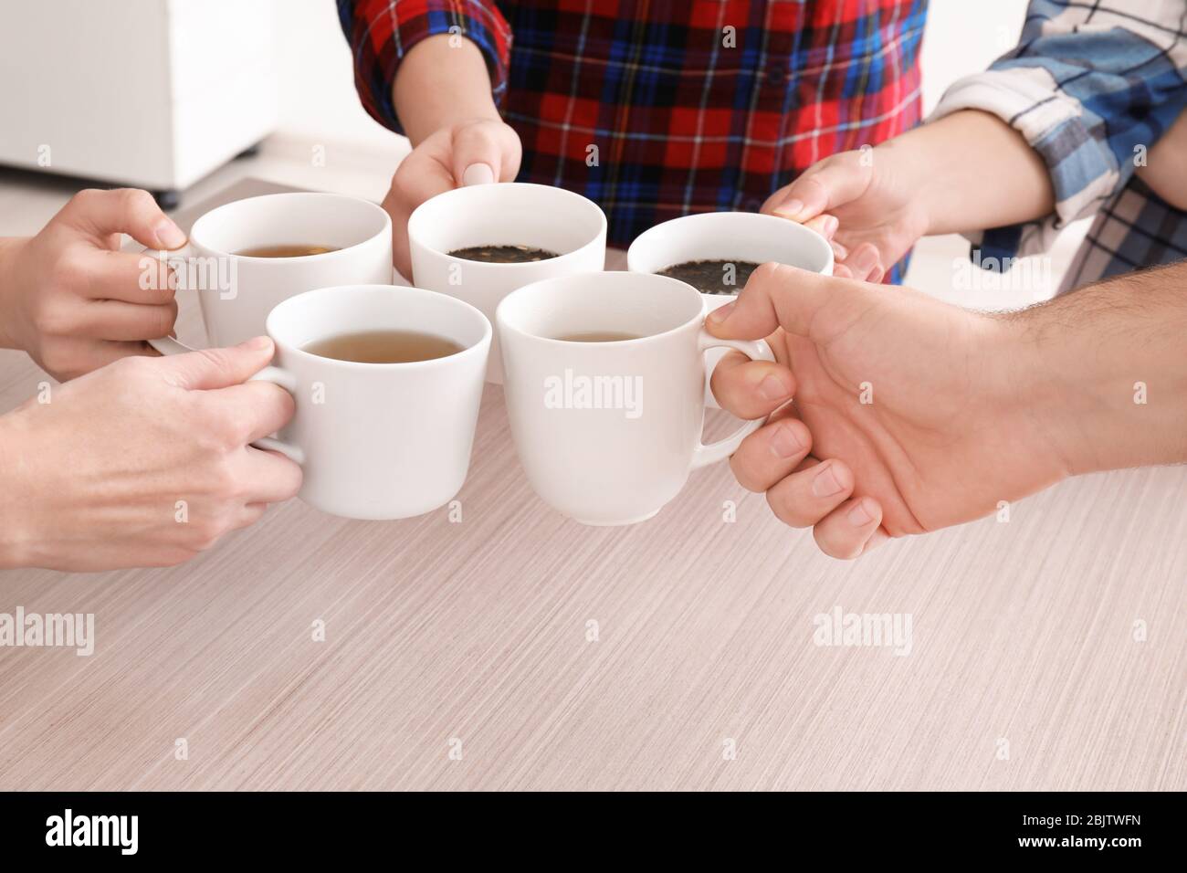 Group of people with cups of tea together at table. Unity concept Stock ...