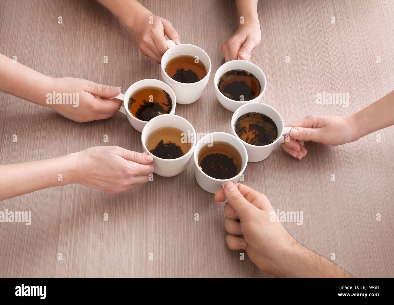 Group of people with cups of tea together at table. Unity concept Stock ...