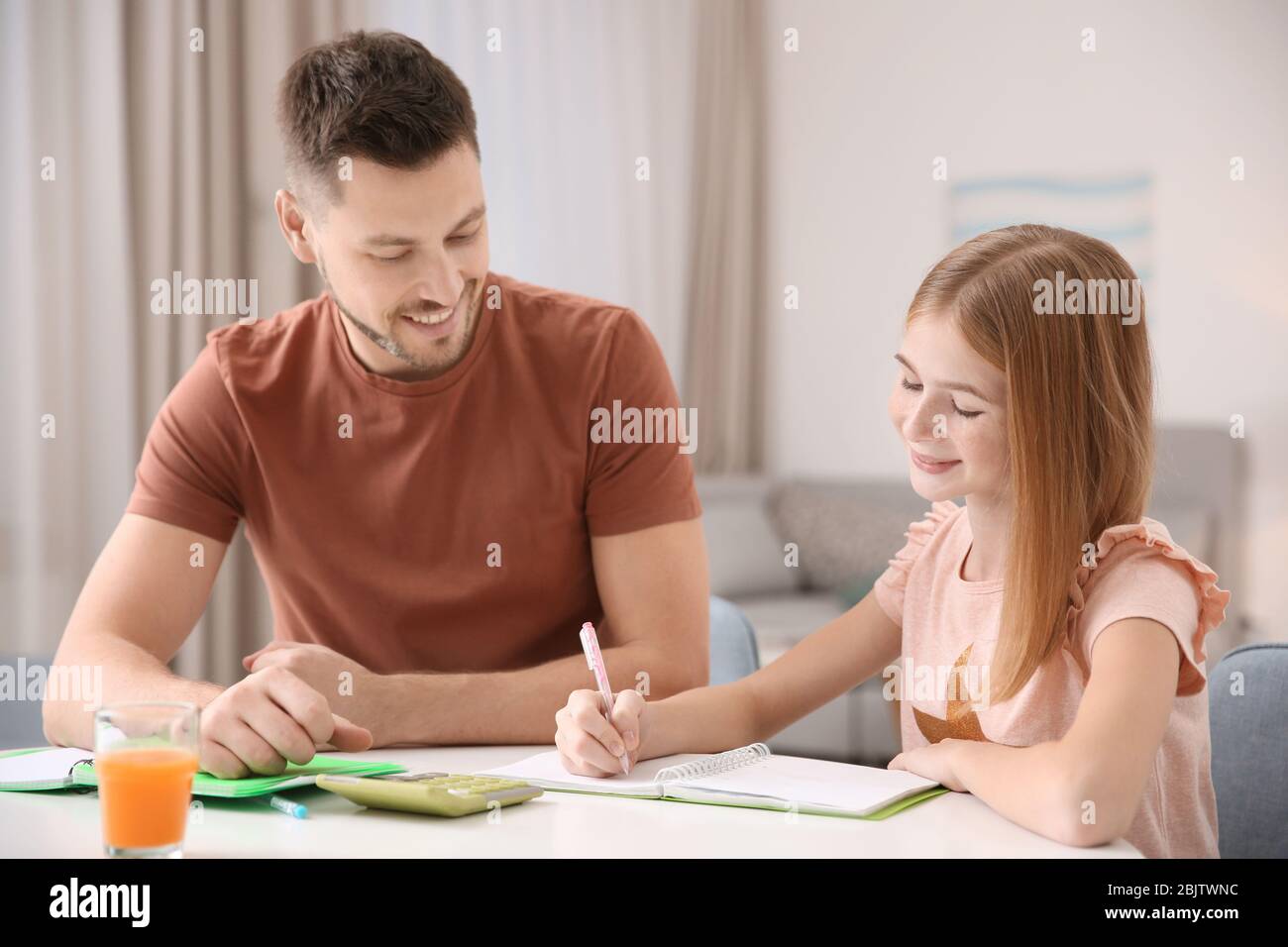 Cute little girl doing homework with father Stock Photo - Alamy