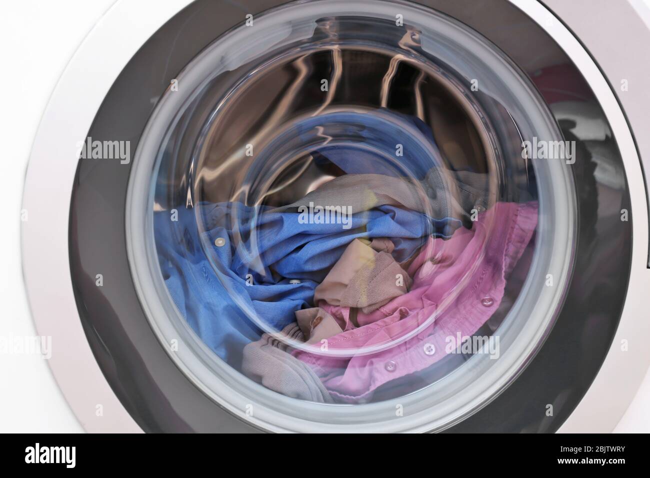 Washing machine with clothes, closeup. Laundry day Stock Photo - Alamy