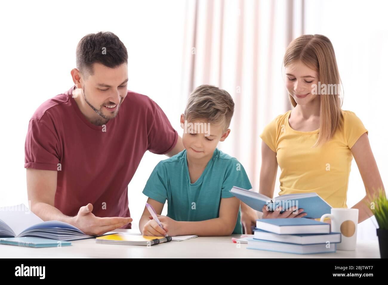 Brother and sister doing homework with father Stock Photo - Alamy