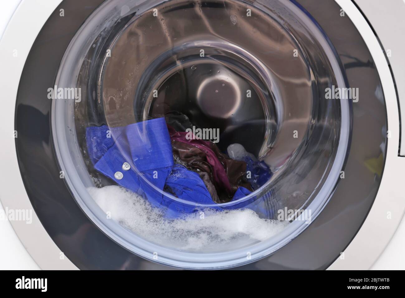 Washing machine with clothes, closeup. Laundry day Stock Photo - Alamy