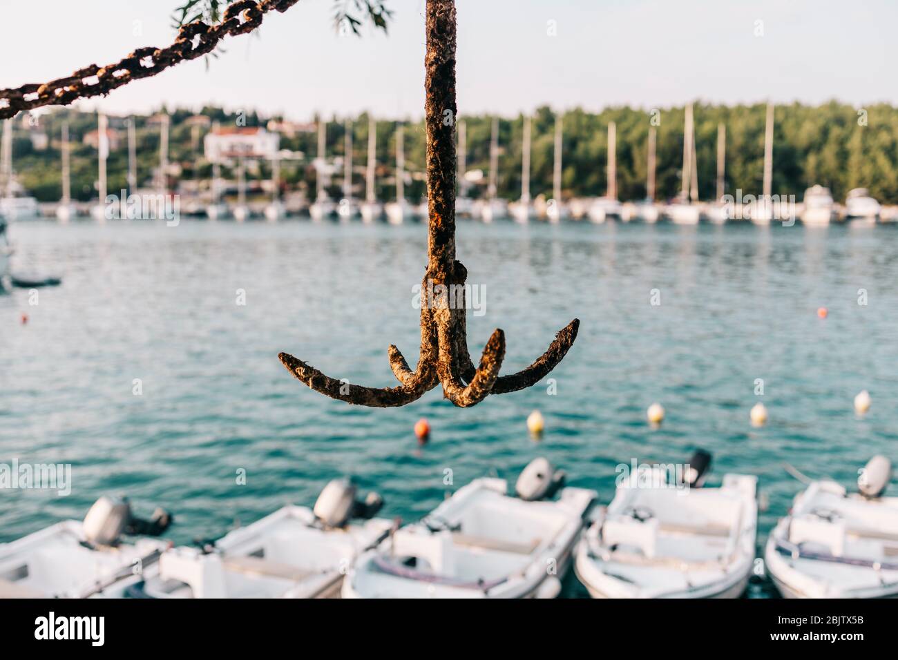 Rusty anchor with a harbour background Stock Photo - Alamy