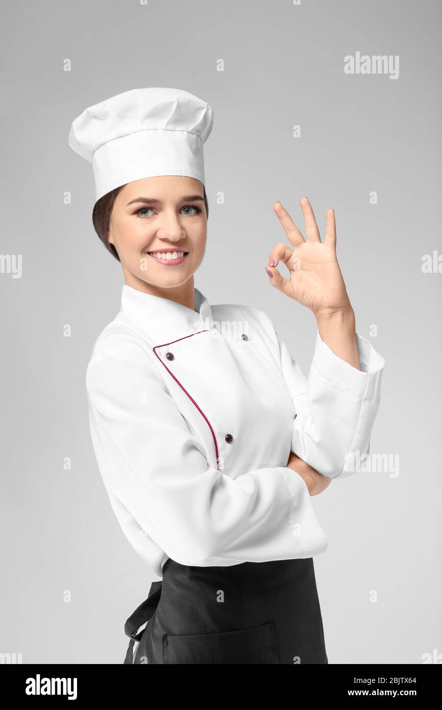 Portrait of female chef on grey background Stock Photo - Alamy
