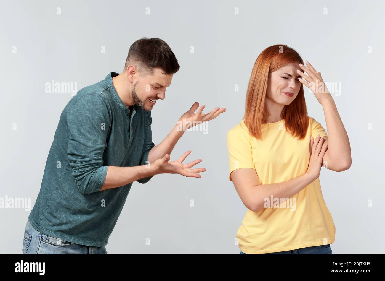 Emotional couple during quarrel on light background Stock Photo - Alamy