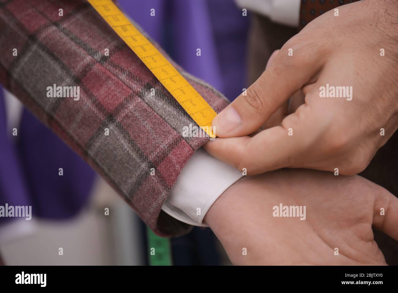 Tailor measuring client for custom made suit in atelier Stock Photo - Alamy