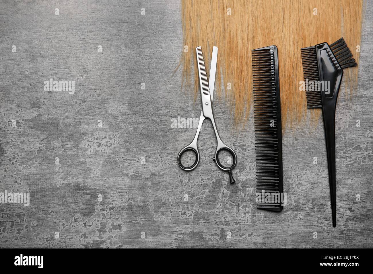 Professional hairdresser's set and blonde hair on grey background Stock ...