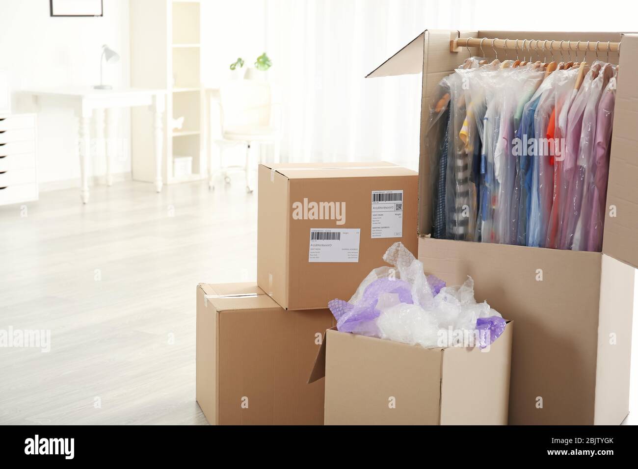 Wardrobe boxes with clothes indoors Stock Photo - Alamy